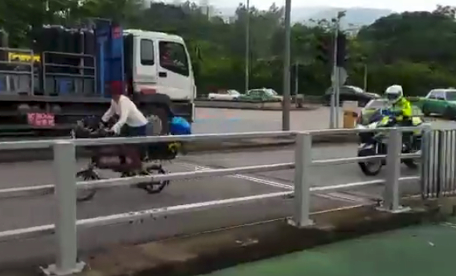 Determined cyclist tries to escape clutches of motorcycle-riding police ...