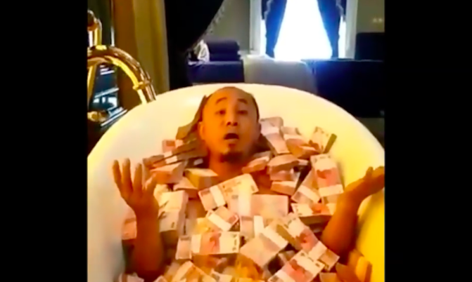 WATCH: Man ‘bathes’ in cash-filled bathtub, promises to donate money to ...