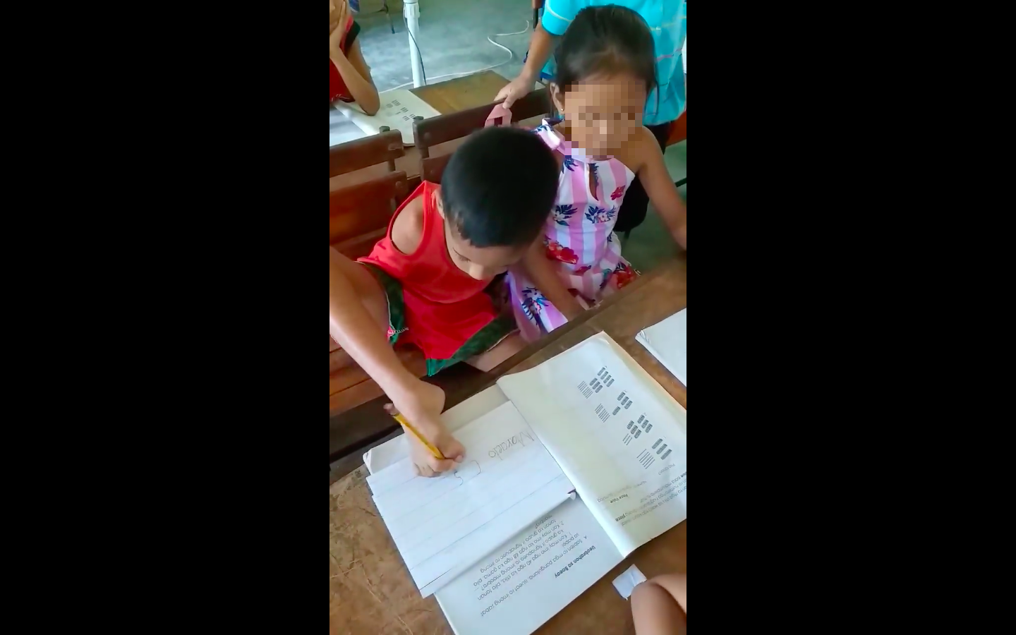 VIRAL: 8-year-old student without arms uses feet to write | Coconuts